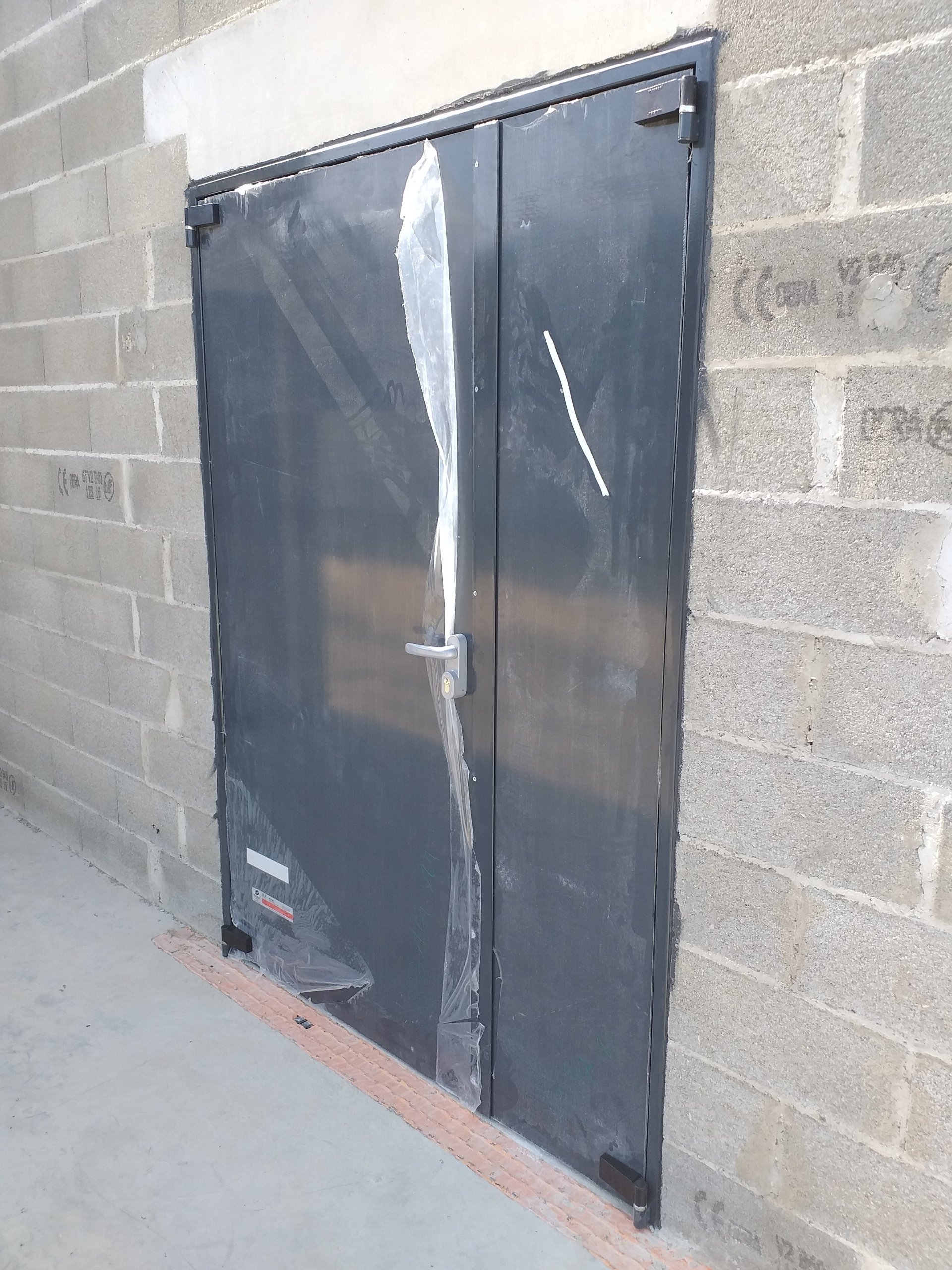 Porte double issue de secours à serrure